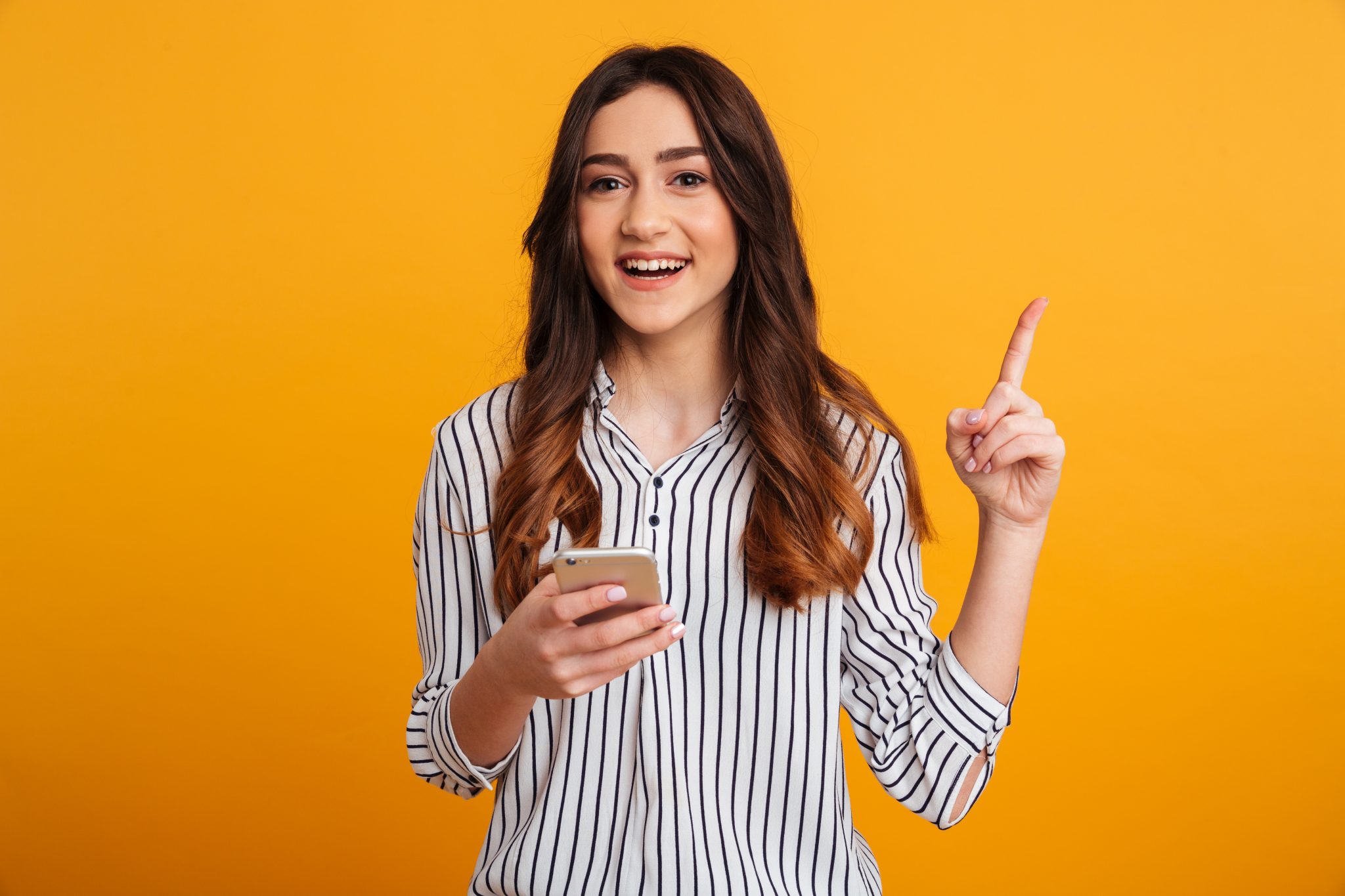 Portrait of an excited young girl holding mobile phone - LinkIdeia Portrait of an excited young girl holding mobile phone - LinkIdeia